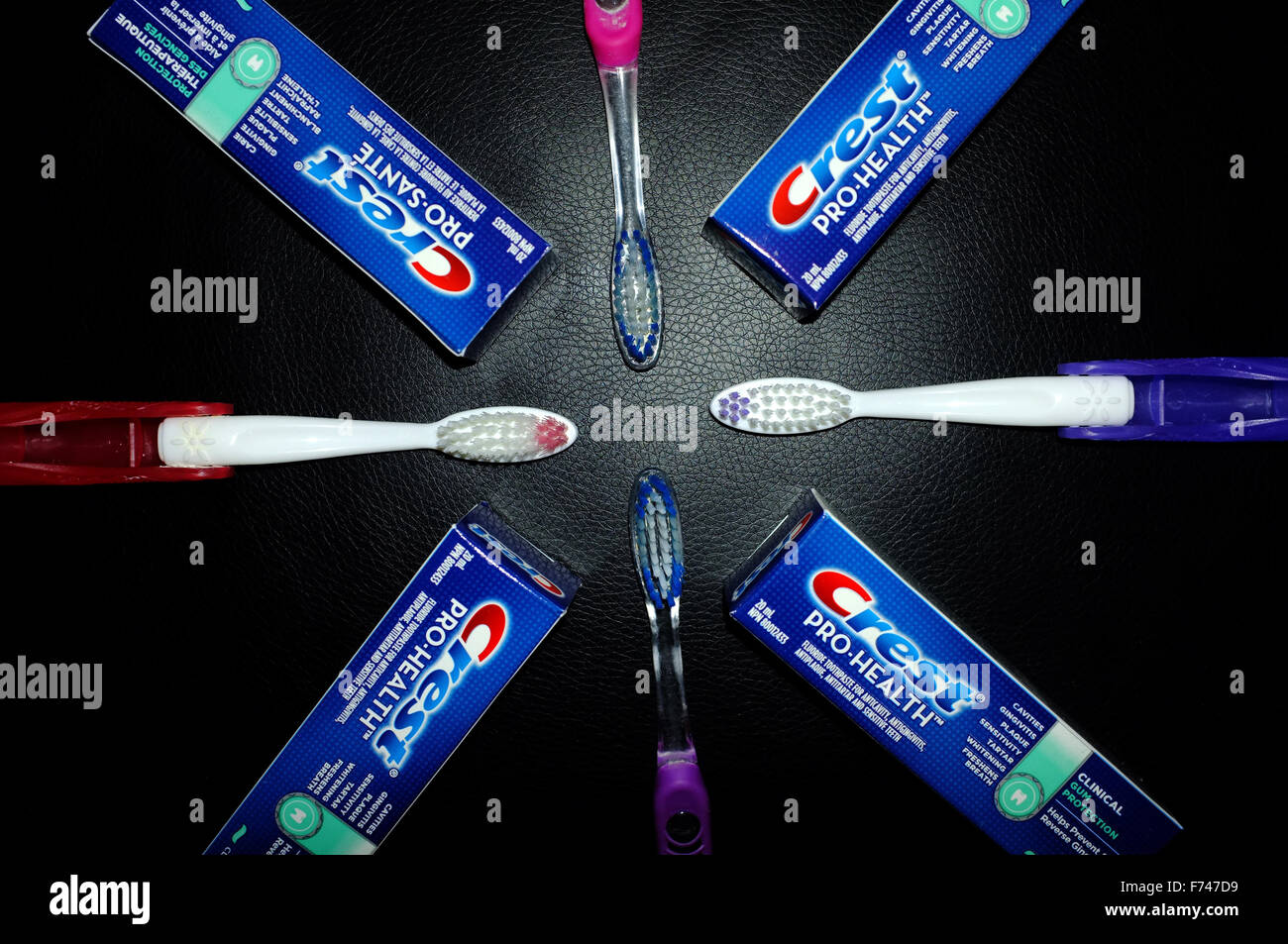 Four toothbrushes with four packets of toothpaste photographed against ...