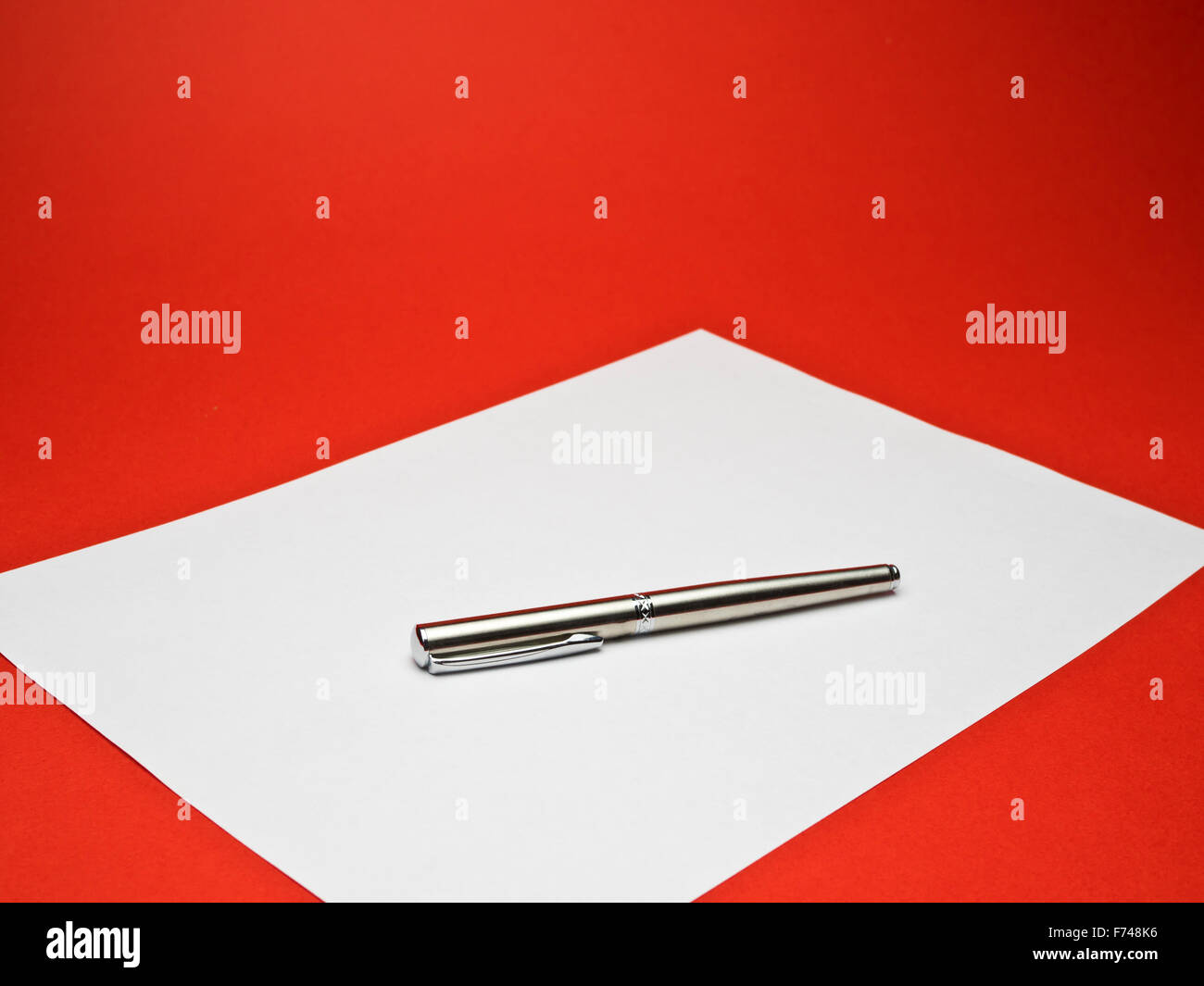 metallic silver pen on white paper with red background Stock Photo - Alamy