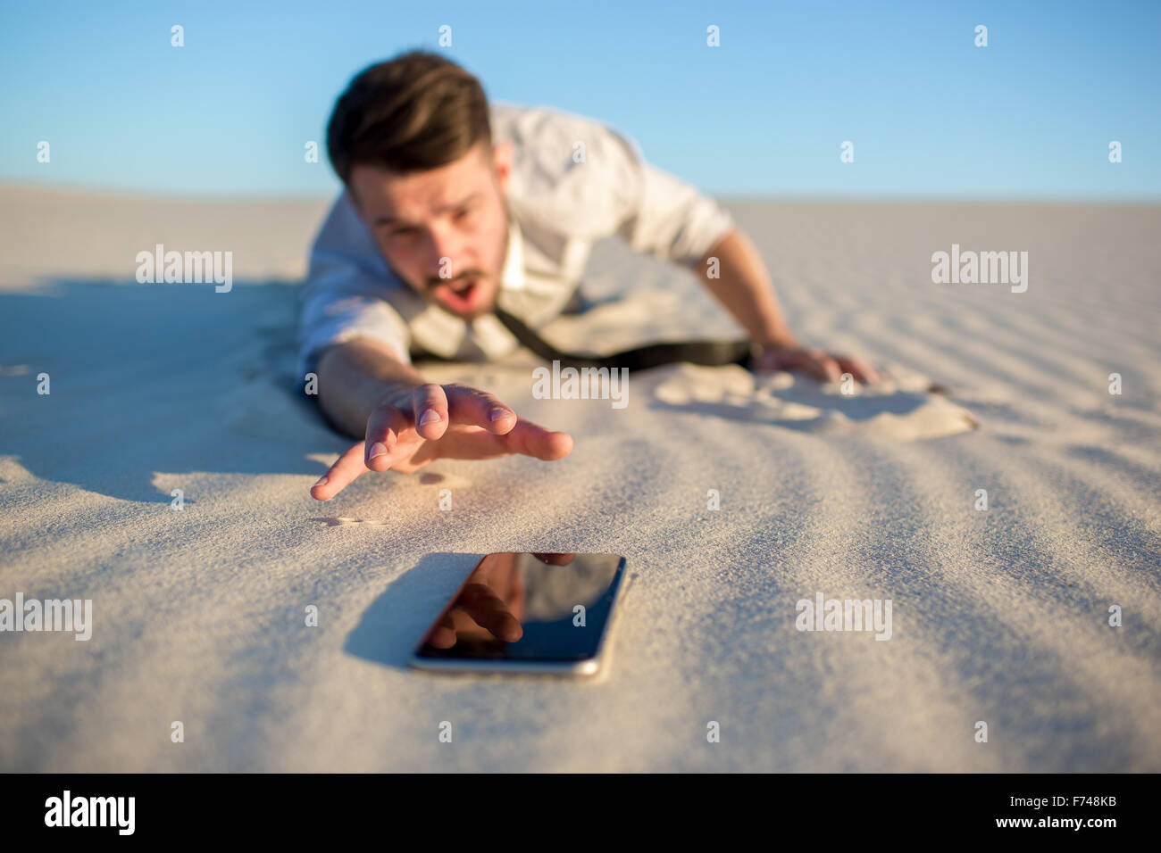 Poor signal. businessman searching for mobile phone signal in desert ...