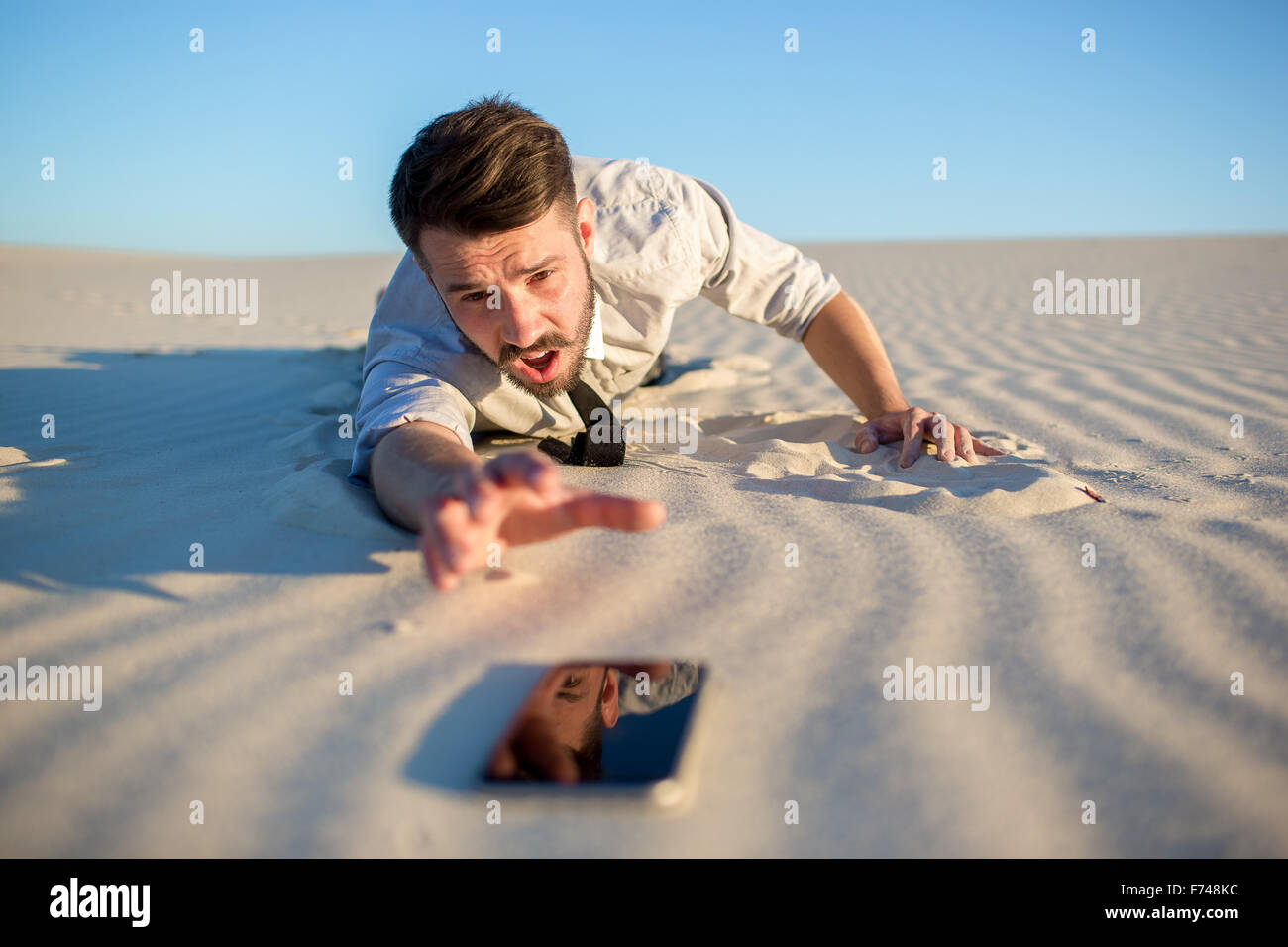 Poor signal. businessman searching for mobile phone signal in desert ...