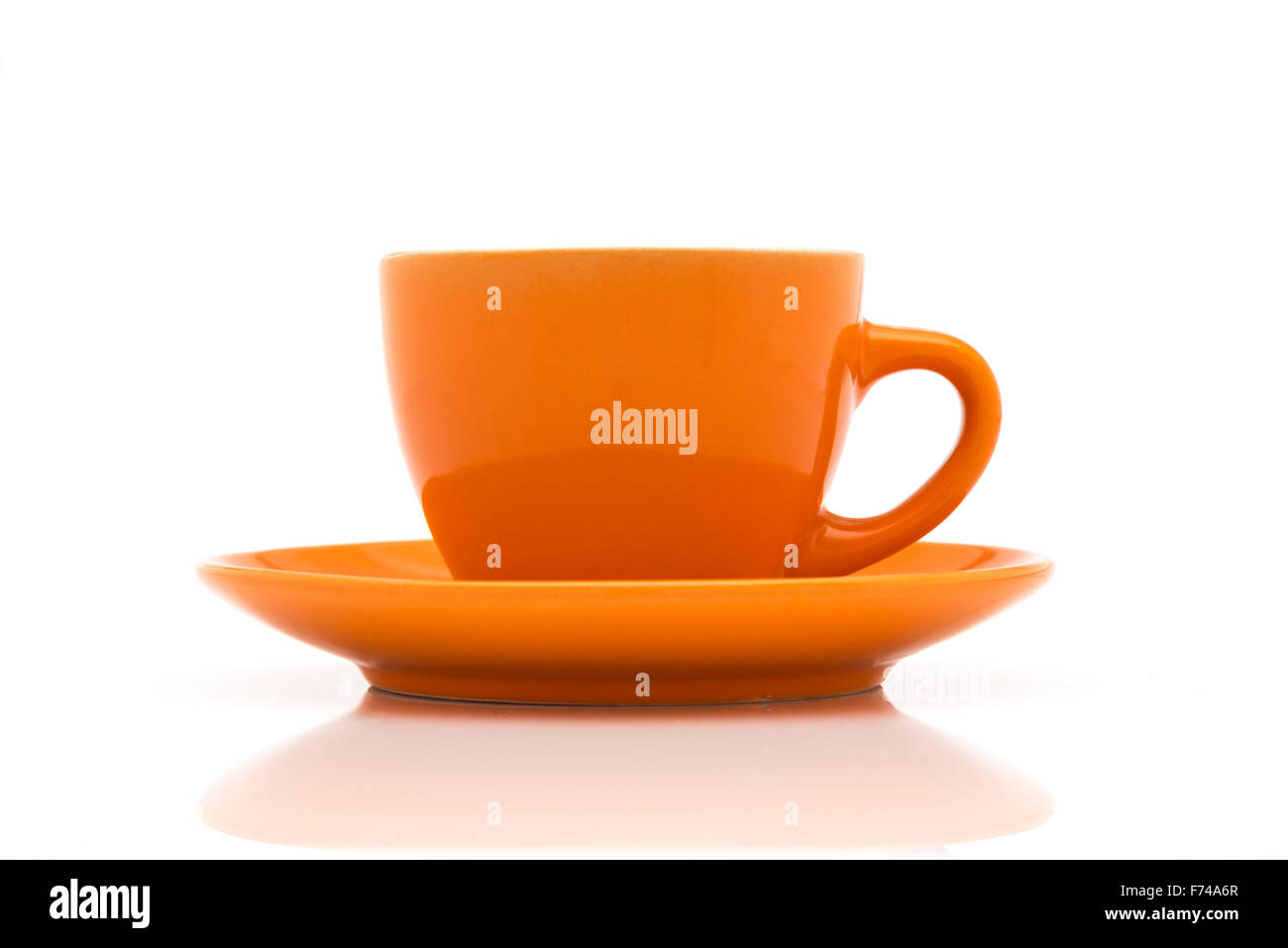 Orange colored espresso cup and saucer isolated on white background ...