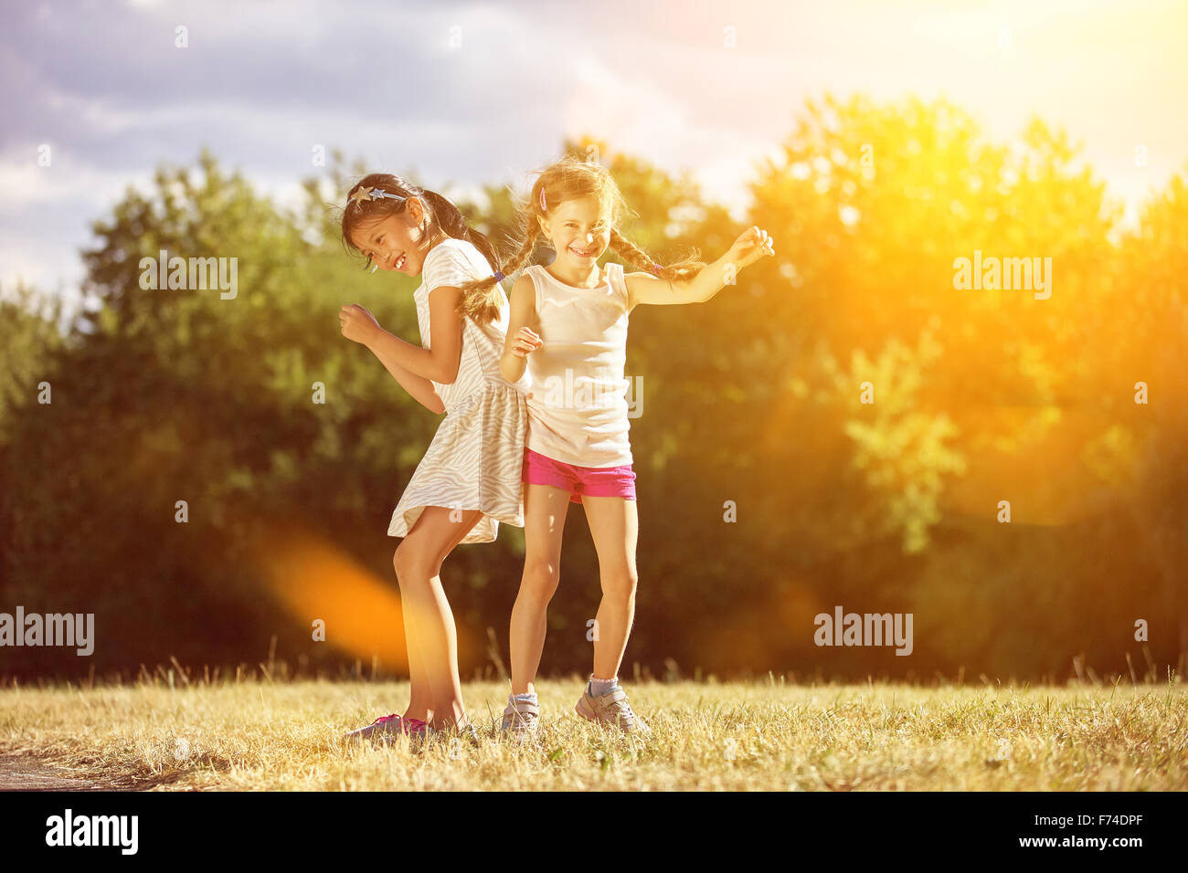 Two grils dancing under the sunshine and having fun Stock Photo - Alamy