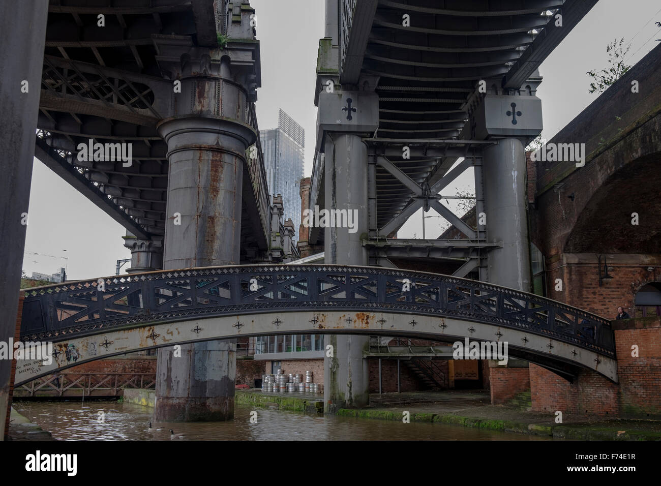 Metal footbridge spanning the canal with two overhead bridges for trams ...