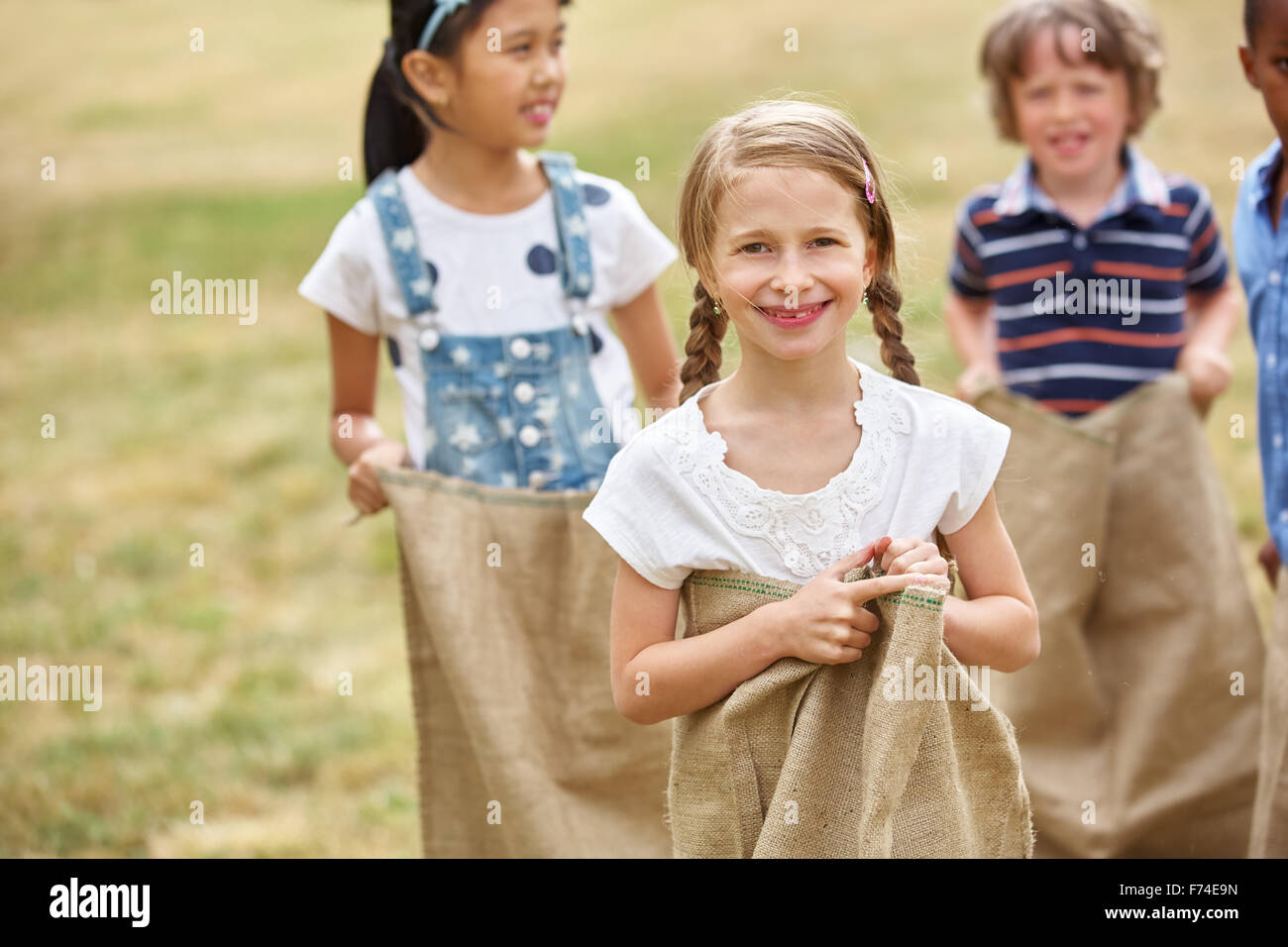 Kids competing at sack race and having fun Stock Photo - Alamy