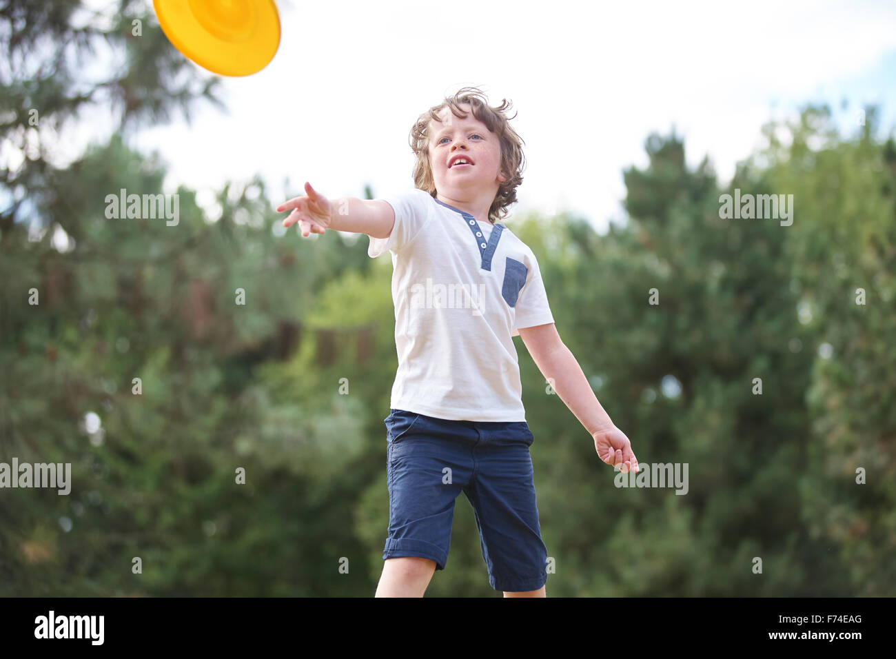 Boy throws frisbee in summer in the nature Stock Photo - Alamy
