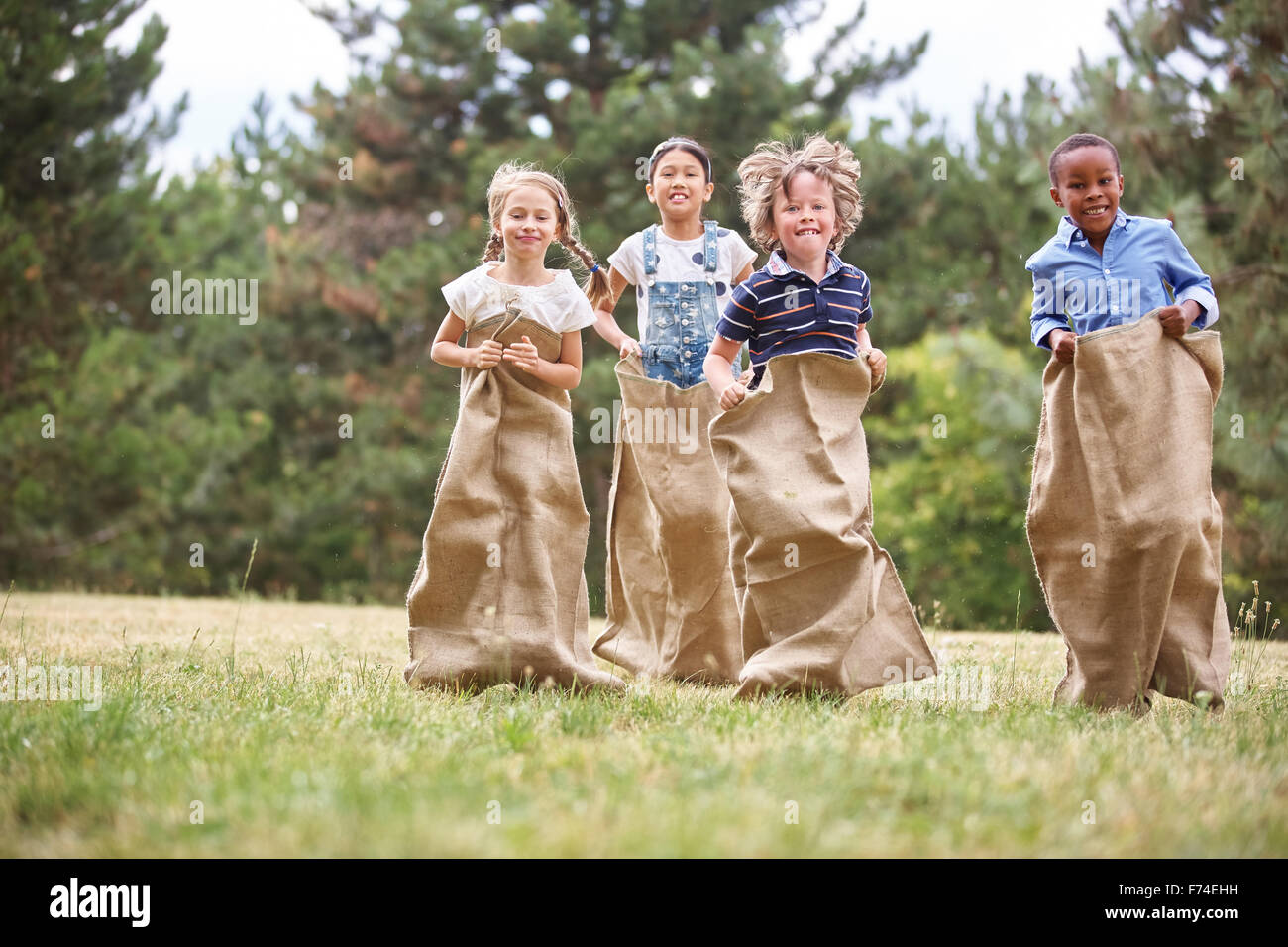 Kids having fun at sack race at the park Stock Photo - Alamy