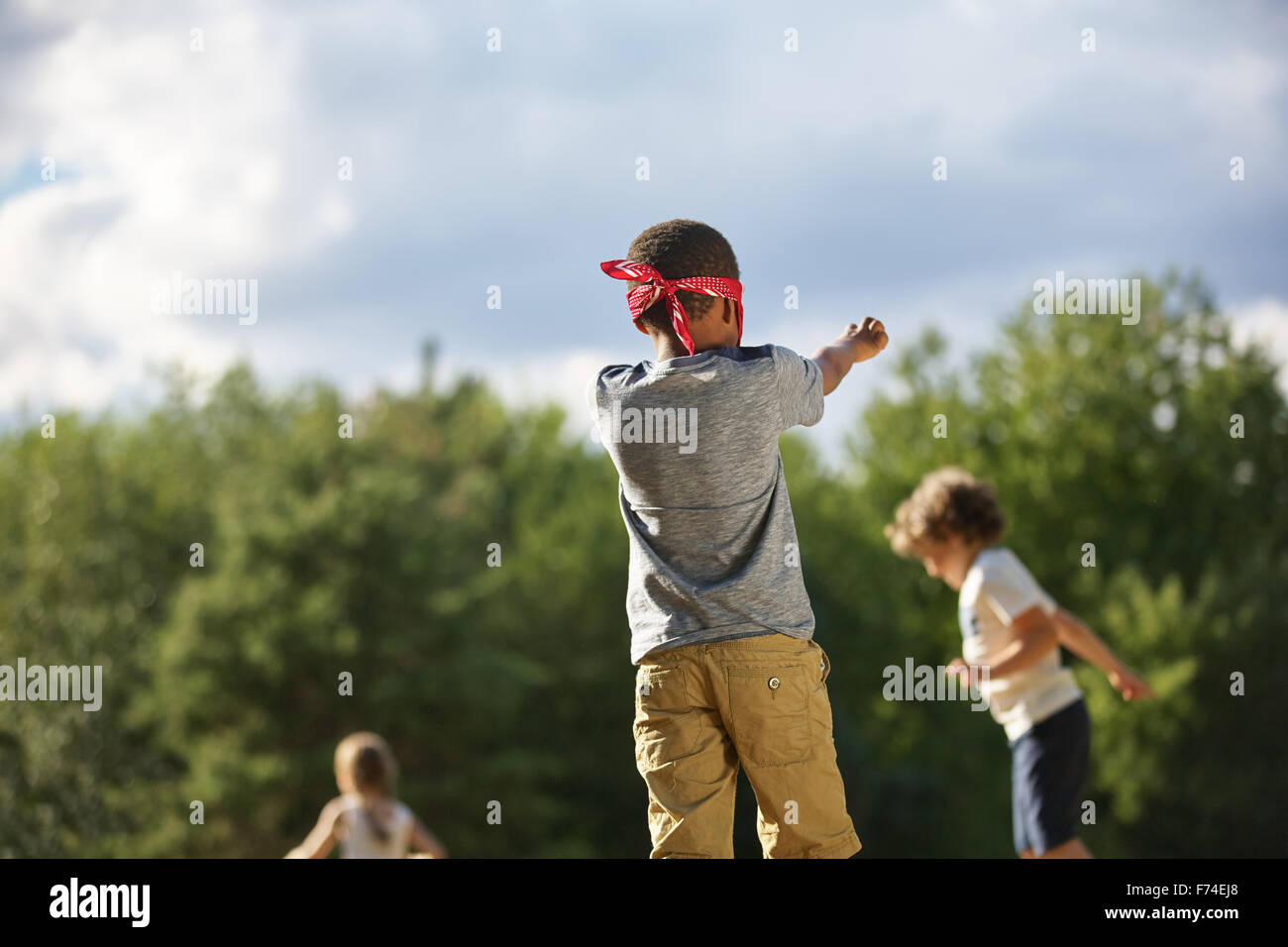 Group of kids plays blind man's buff in summer at the park Stock Photo ...
