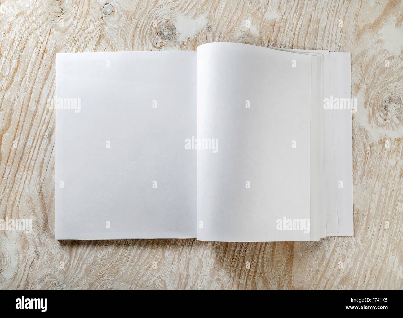 Blank opened book on light wooden background with soft shadows. Mock-up ...