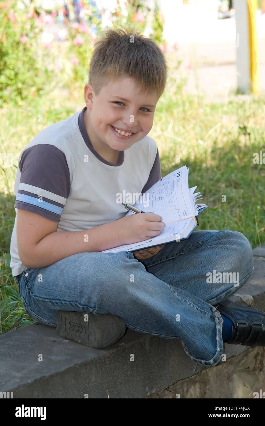 boy writes to writing-books Stock Photo - Alamy