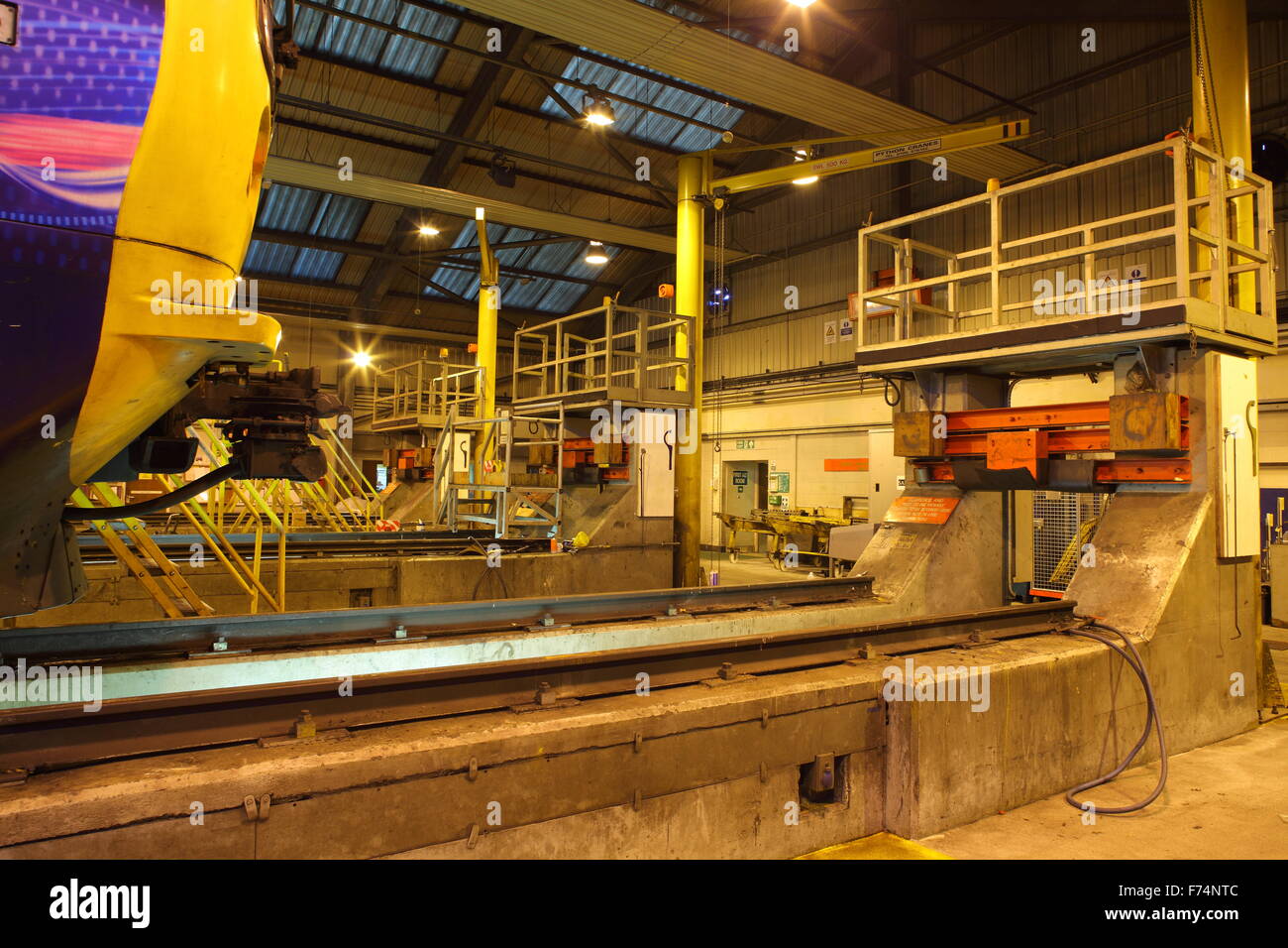 The front end of a train high up on rails inside a maintenance shed ...