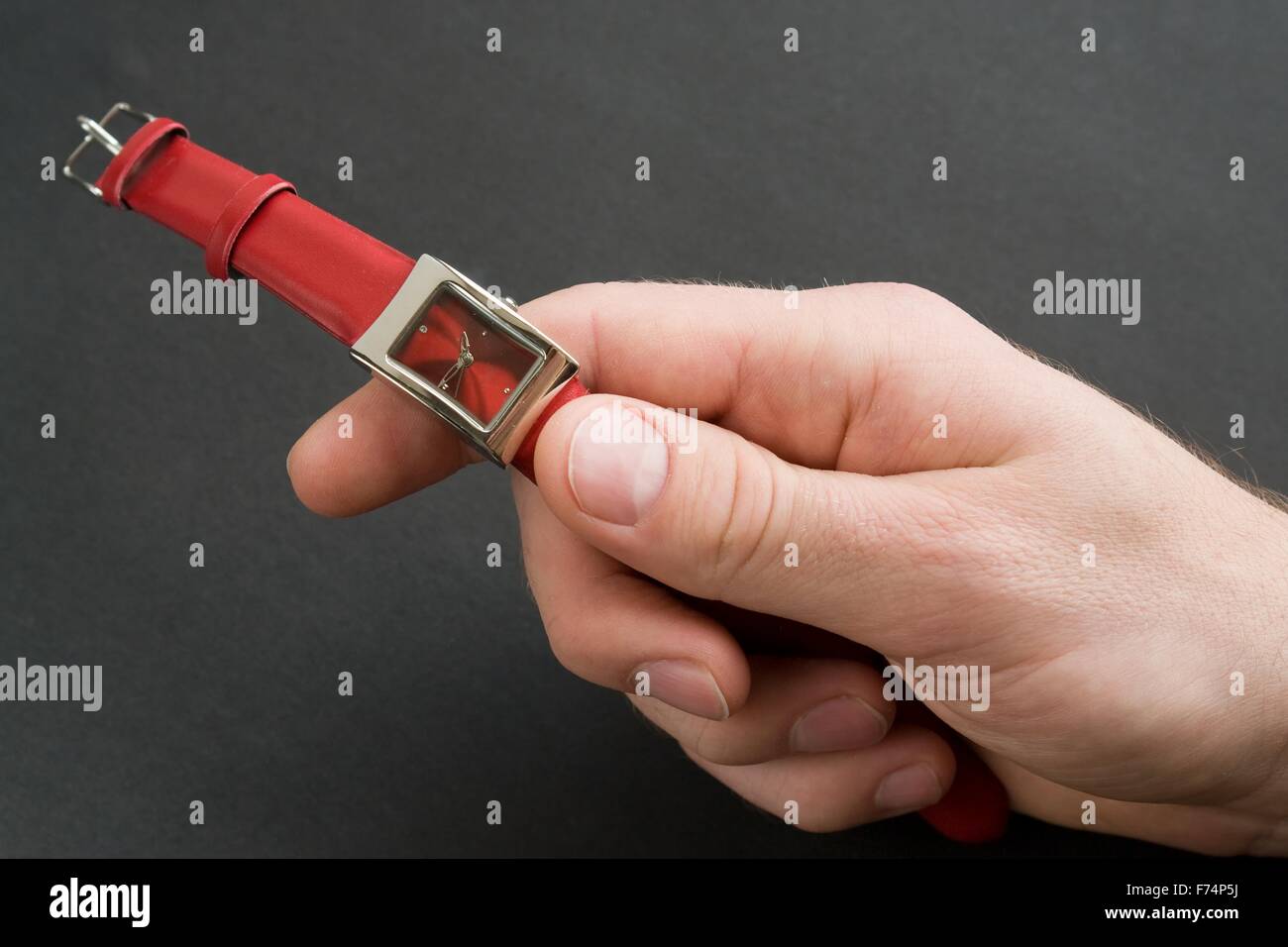 Hand with red watch Stock Photo - Alamy