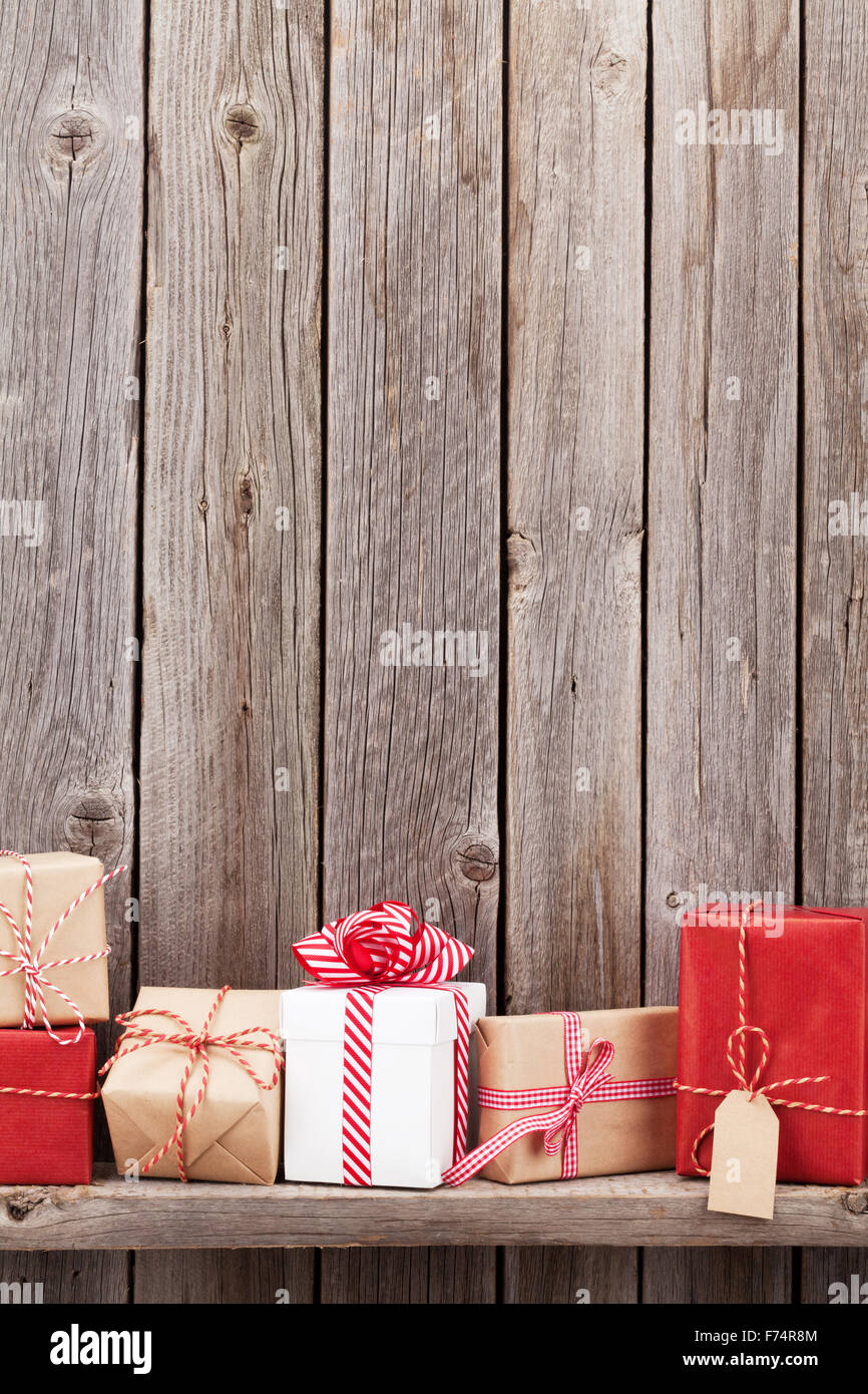 Christmas gift boxes in front of wooden wall. View with copy space ...