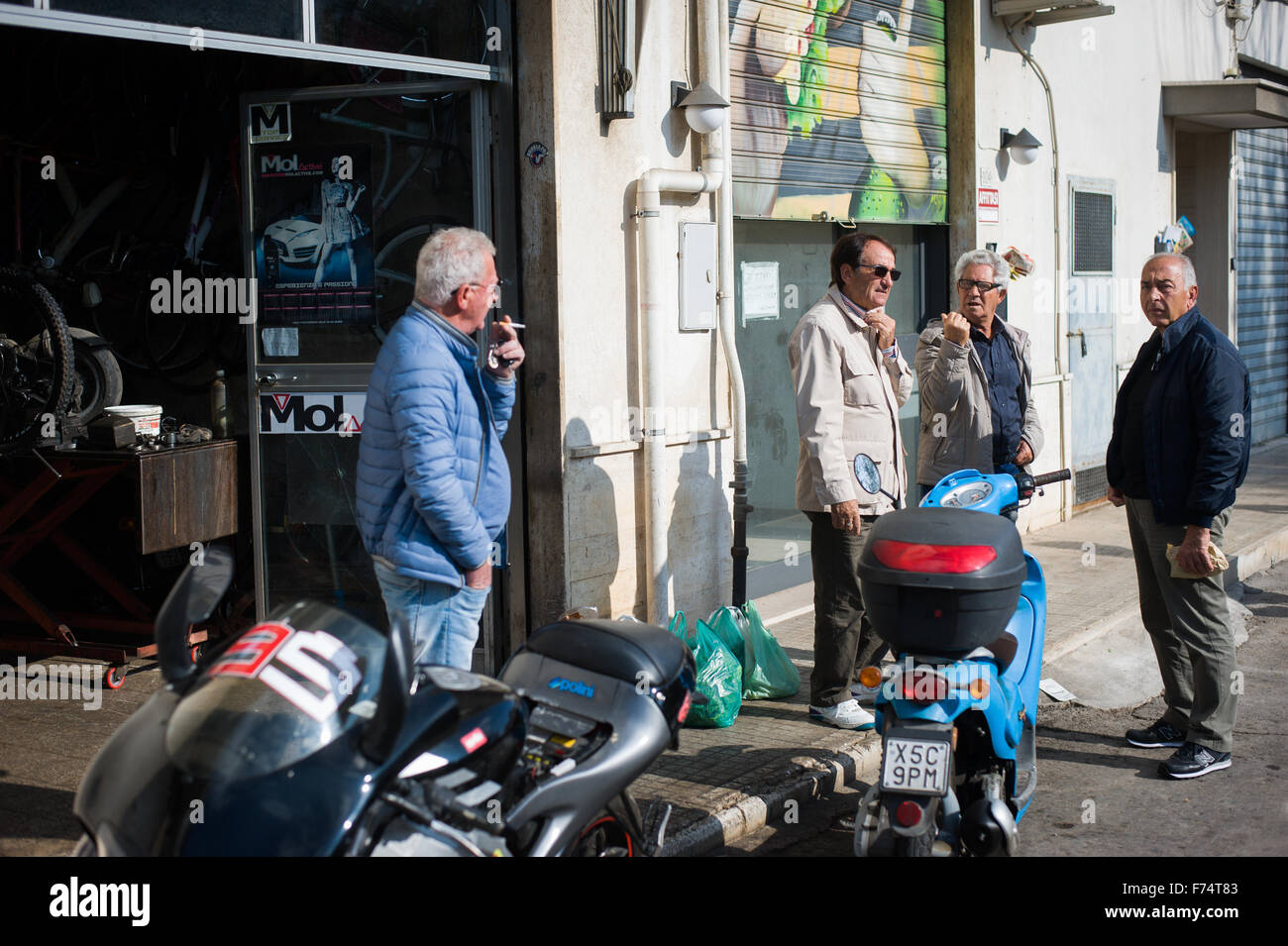 Italian men talking and smoking next to mopeds outside cafe Stock Photo ...