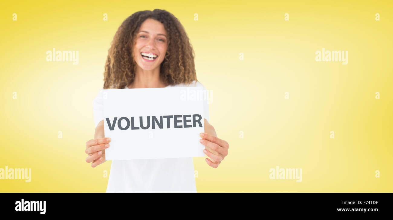 Composite image of smiling volunteer showing a poster Stock Photo - Alamy