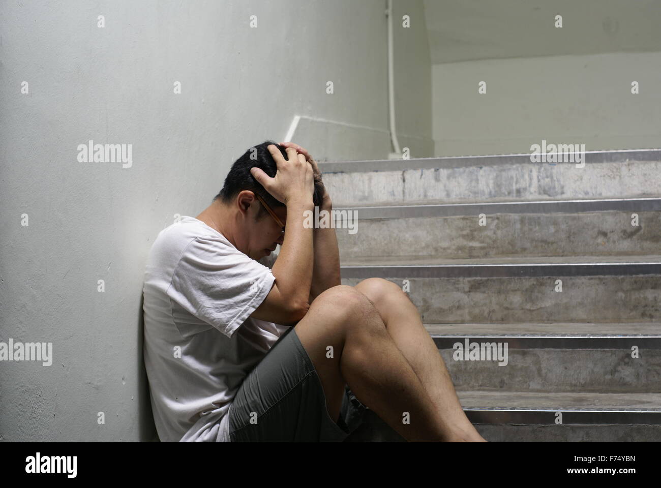 Frustrated man sitting alone Stock Photo - Alamy