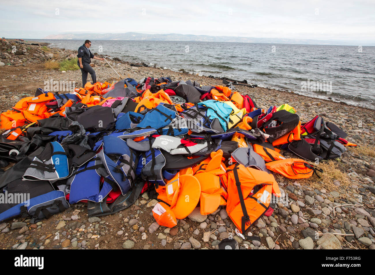 A police man inspects life jackets and remains of boats left by Syrian ...