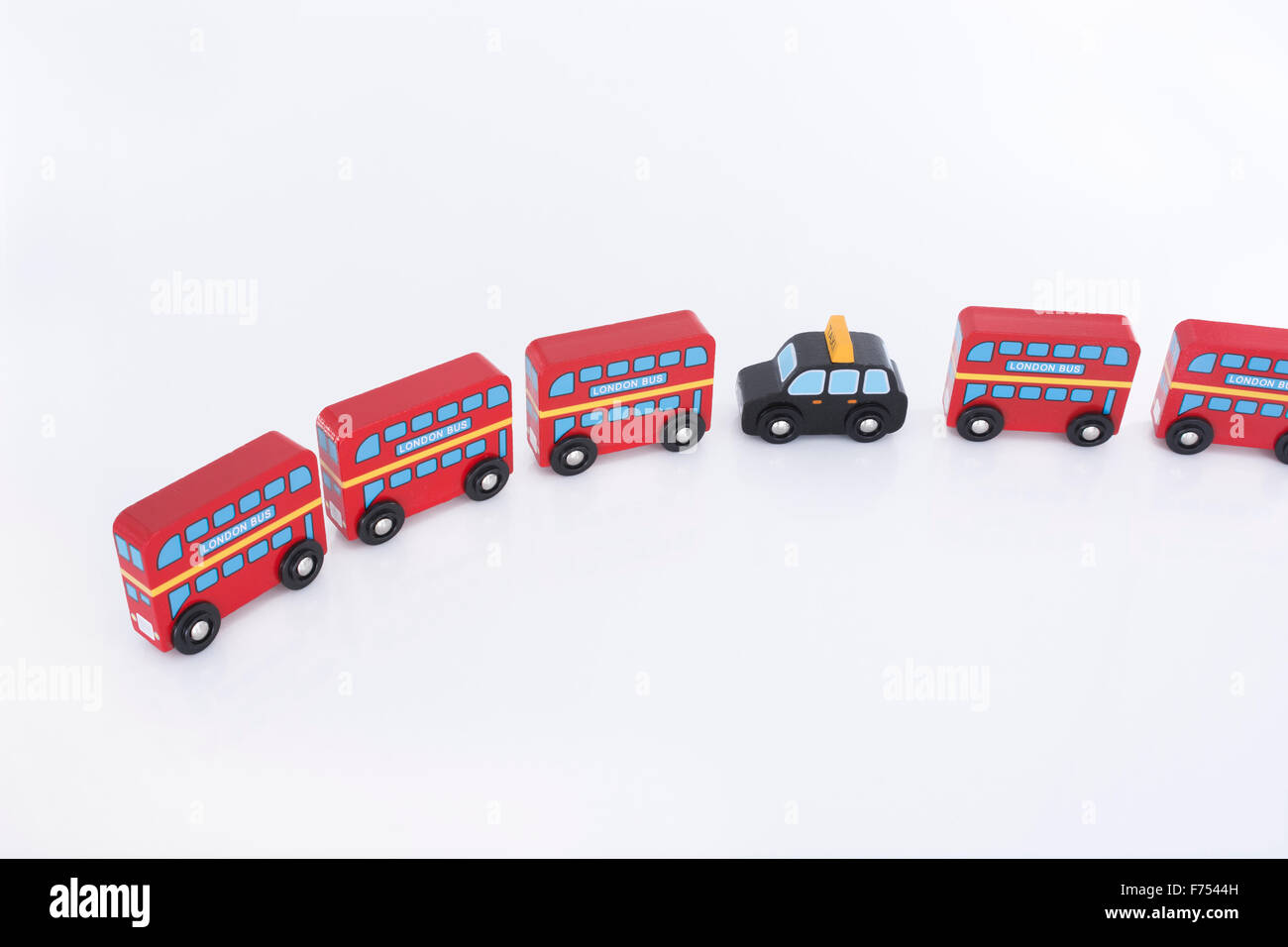 Red London buses & black cab (taxi) wooden toys on white background ...