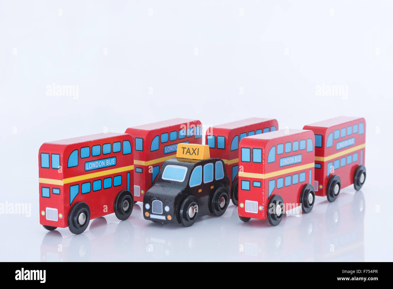 Red London buses & black cab (taxi) wooden toys on white background ...
