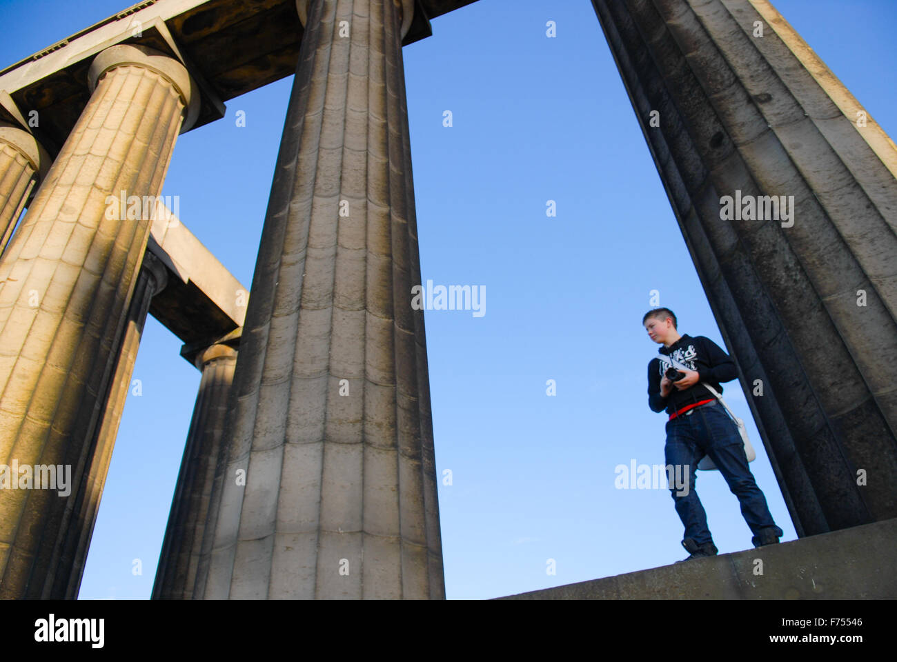 A teenage boy with a camera at the National Monument of Scotland on ...