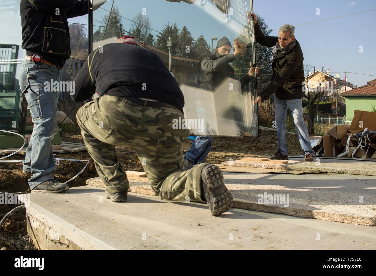 Construction workers installing new windows in a house under ...