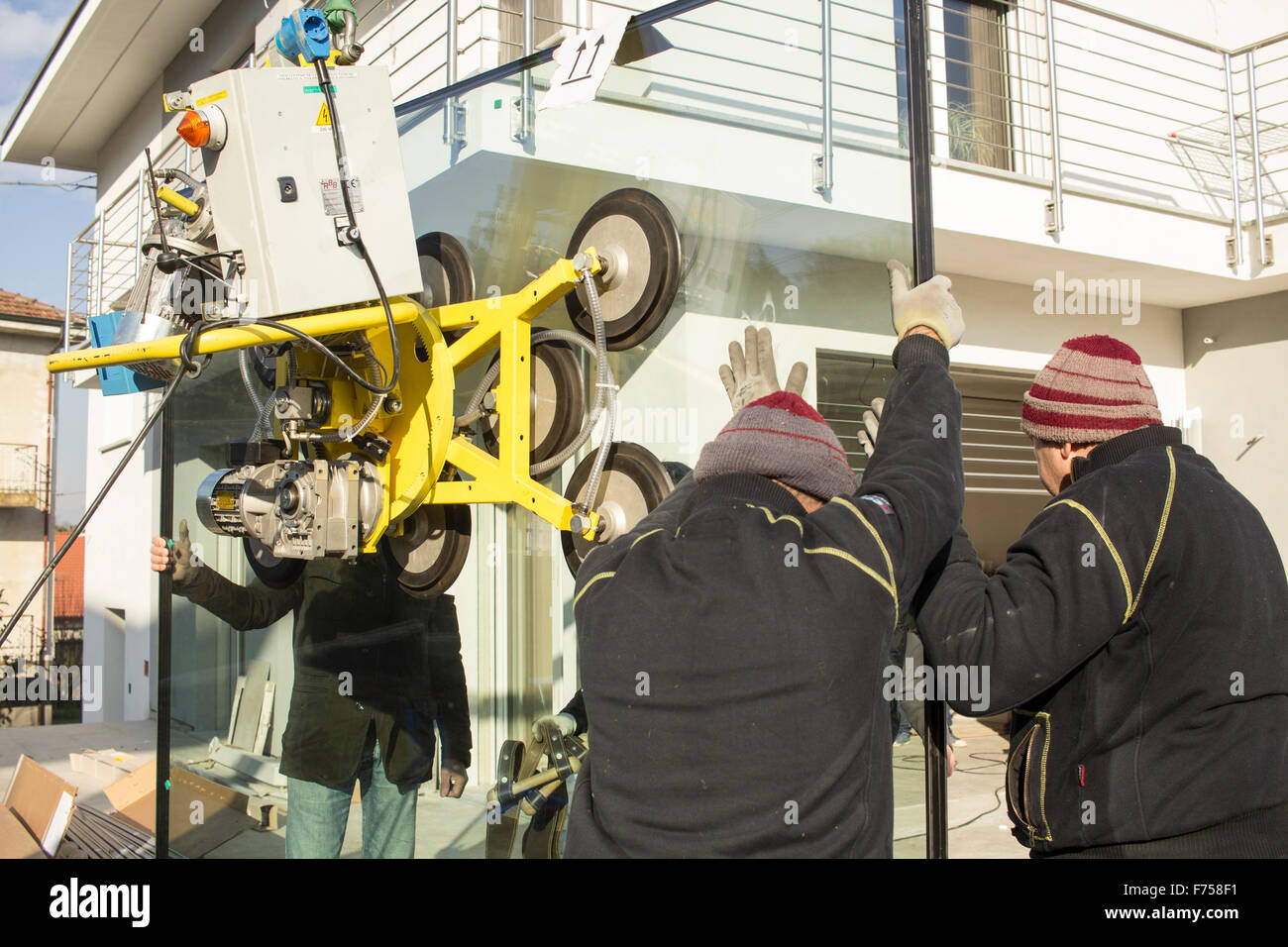 Construction workers installing new windows in a house under ...