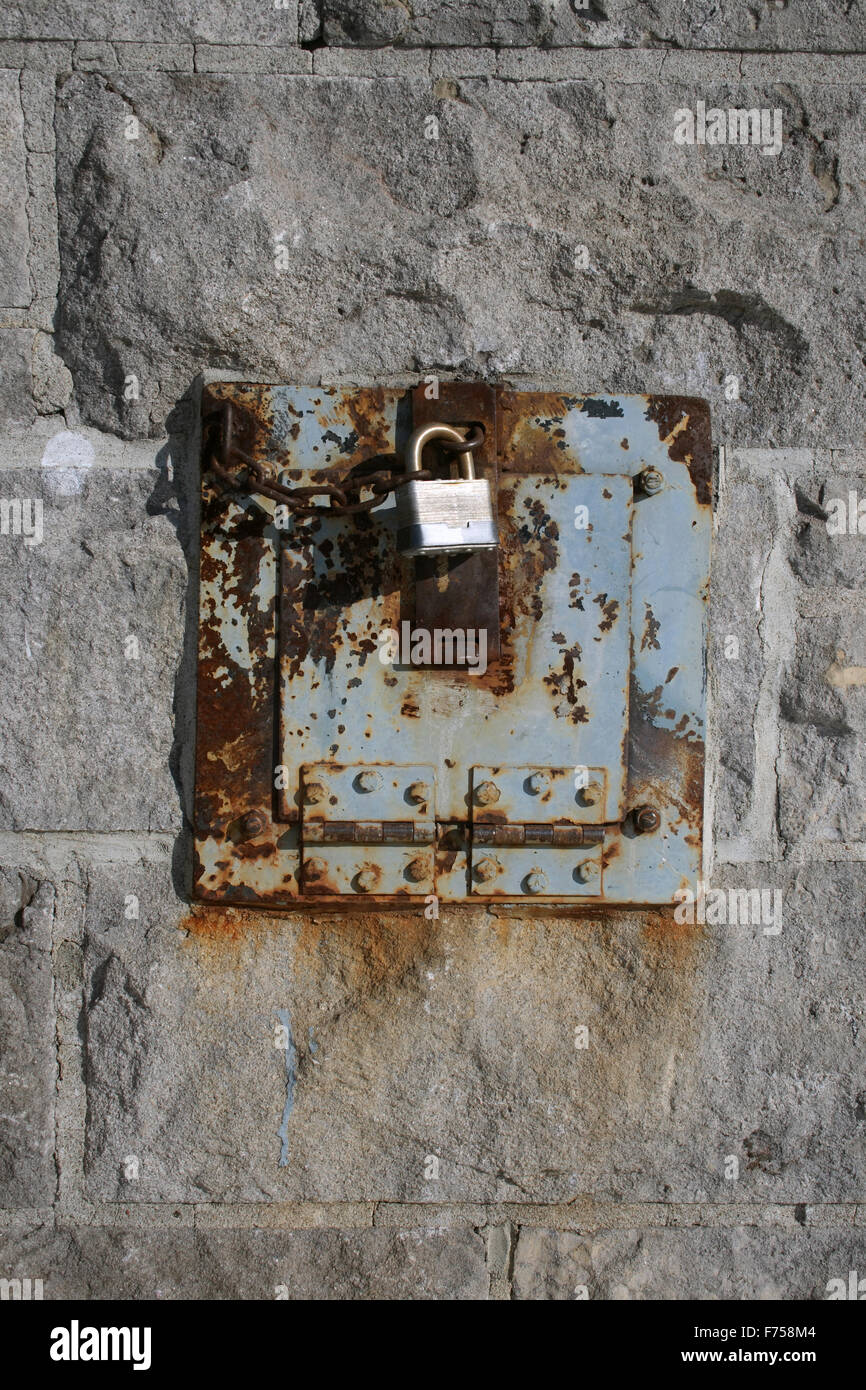 Iron lock and rusty chain on a stone wall Stock Photo - Alamy