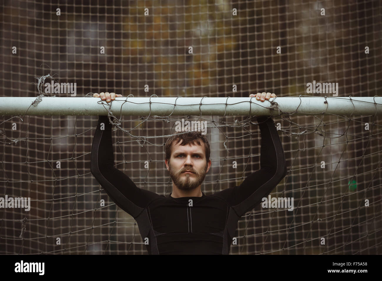 Male athlete resting on soccer field urban view Stock Photo - Alamy