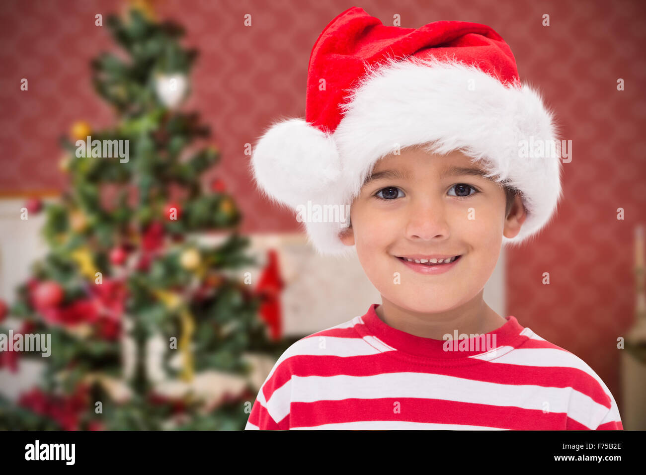 Composite image of cute little boy in santa hat Stock Photo - Alamy