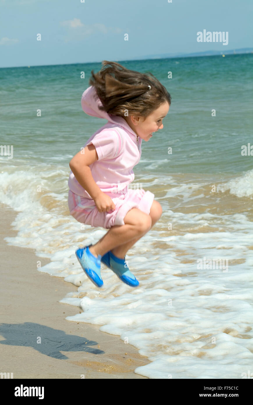 Child jumping over waves hi-res stock photography and images - Alamy