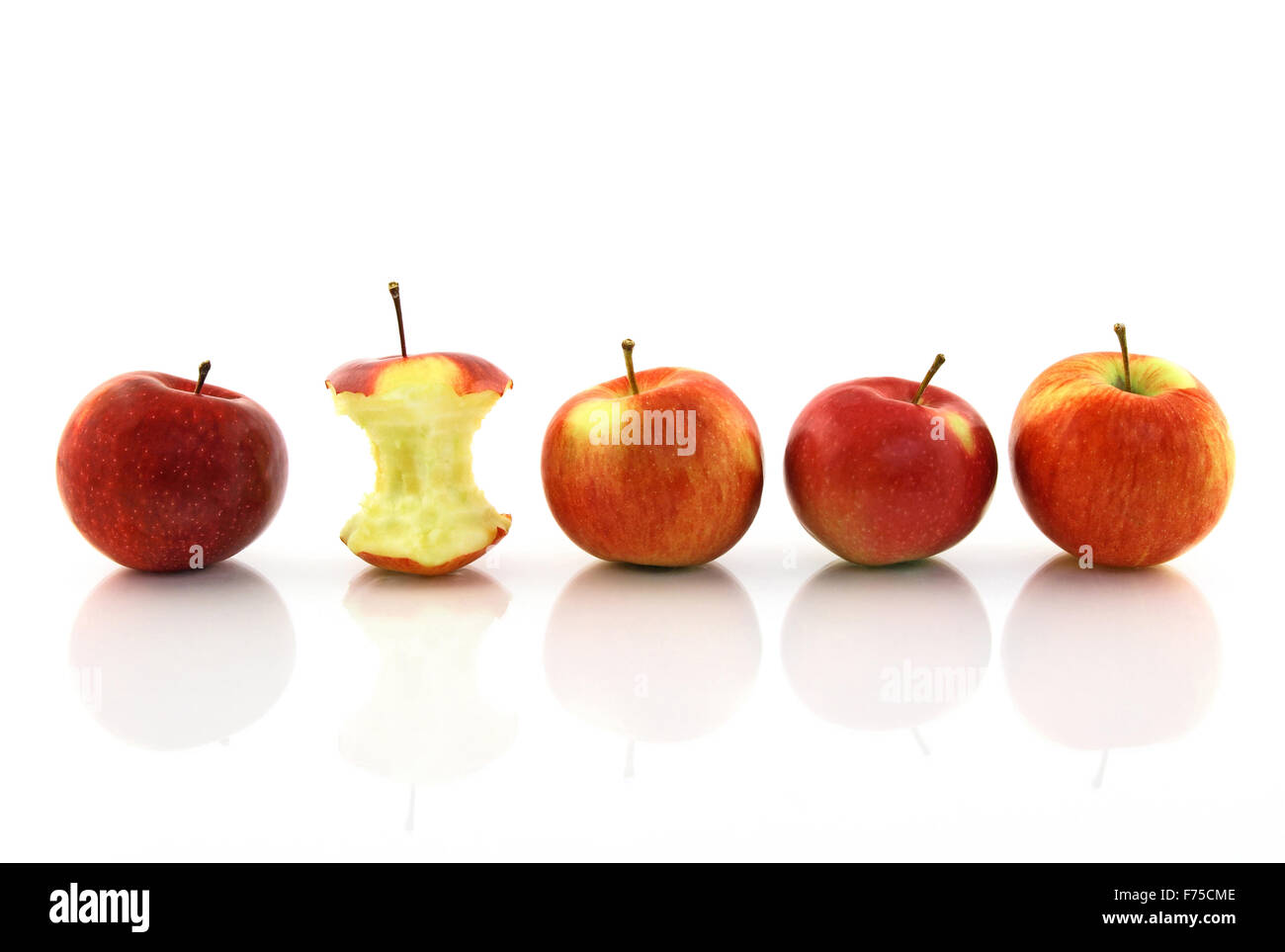 Apple core among whole apples Stock Photo - Alamy