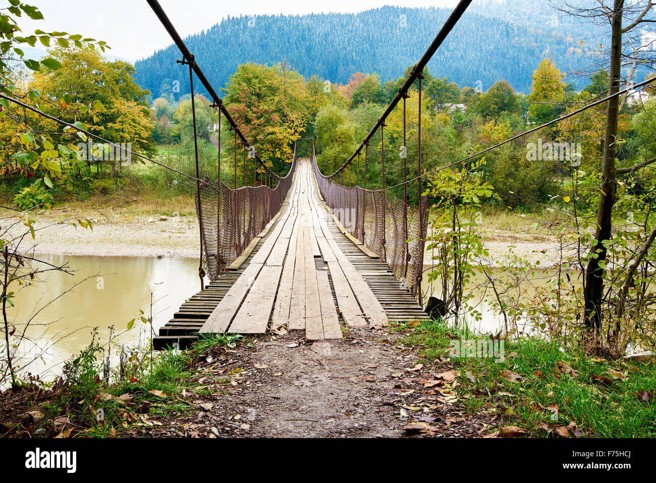 Suspension hanging bridge over mountain river Stock Photo - Alamy