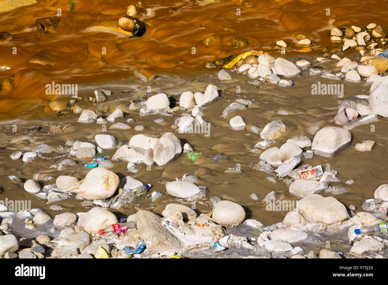 A river full of water contaminated by mine effluent, mixing with raw ...