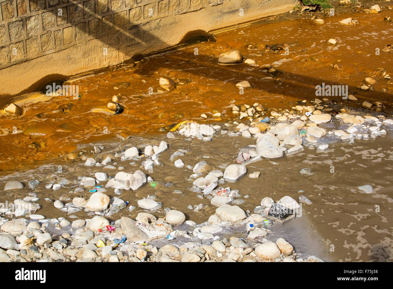 A river full of water contaminated by mine effluent, mixing with raw ...