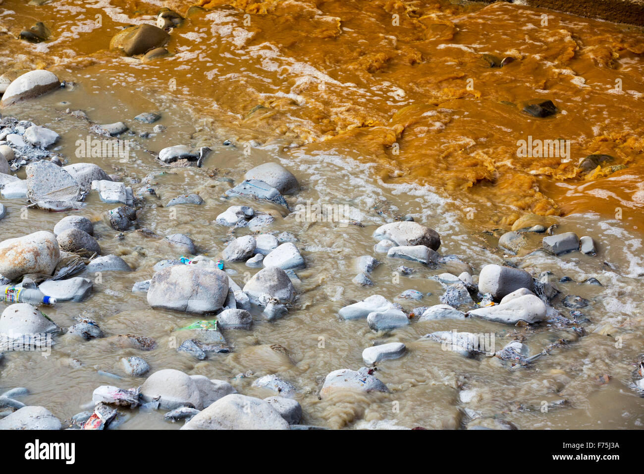 A river full of water contaminated by mine effluent, mixing with raw ...