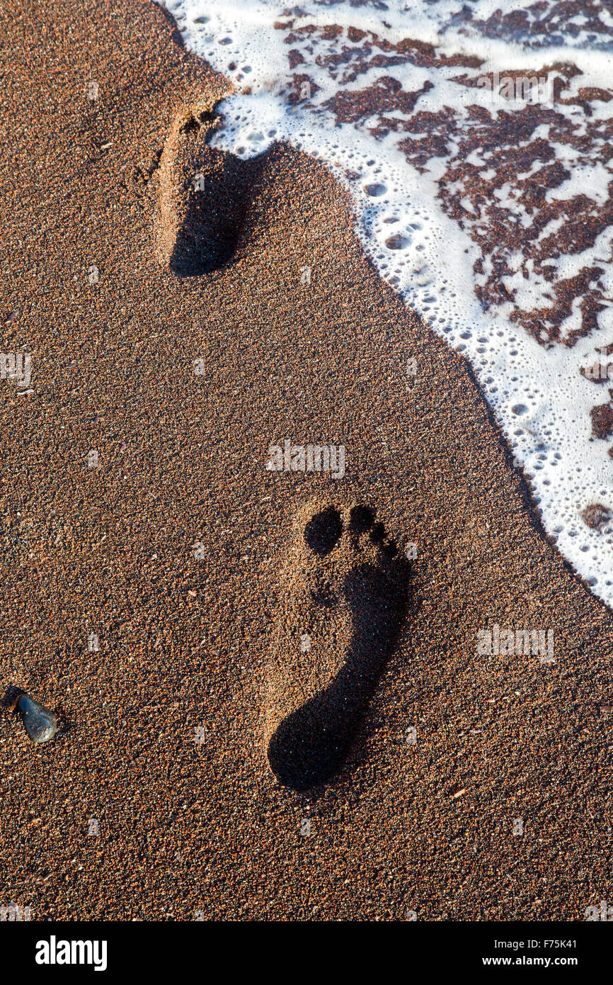 Trail of foot steps on the beach Stock Photo - Alamy