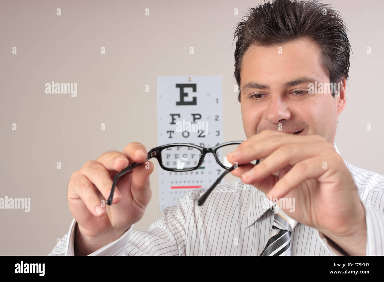Optometrist examining eye glasses Stock Photo - Alamy
