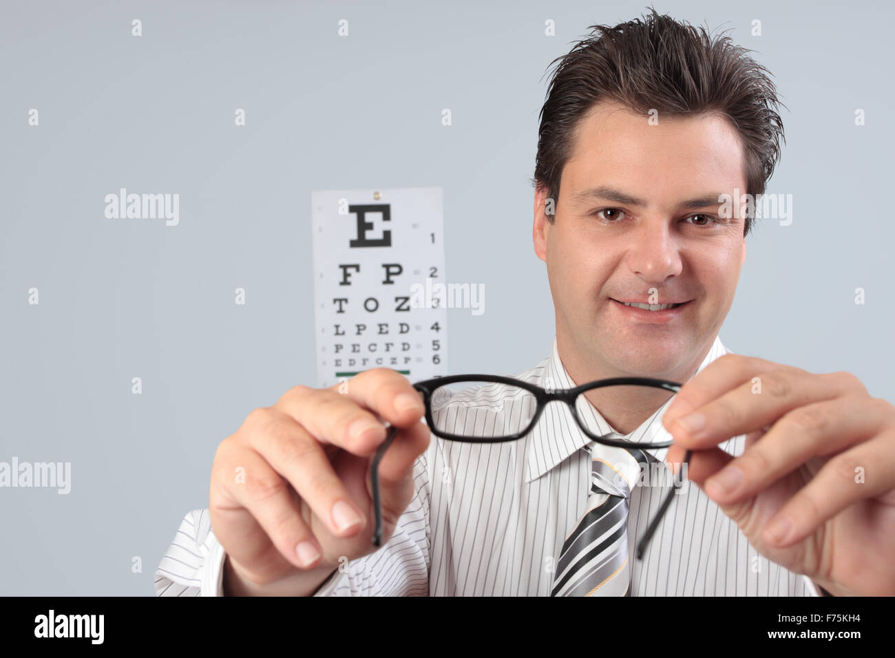 Optometrist holding eye frames Stock Photo - Alamy