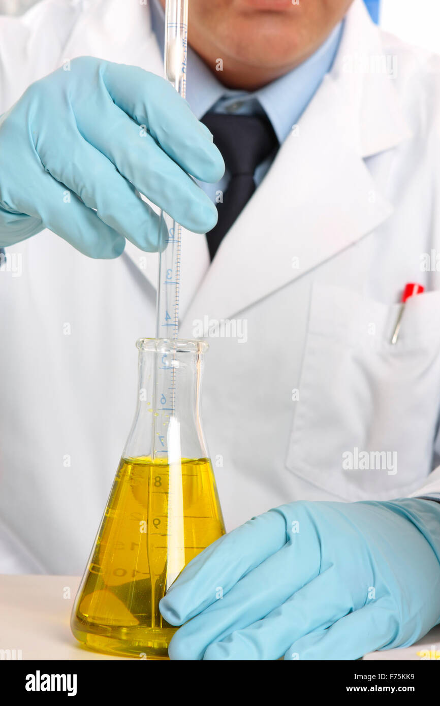Scientist stirring liquid in flask Stock Photo - Alamy