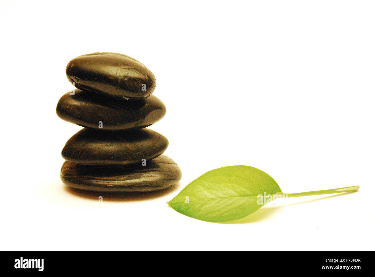 Spa stones with green leaf Stock Photo - Alamy