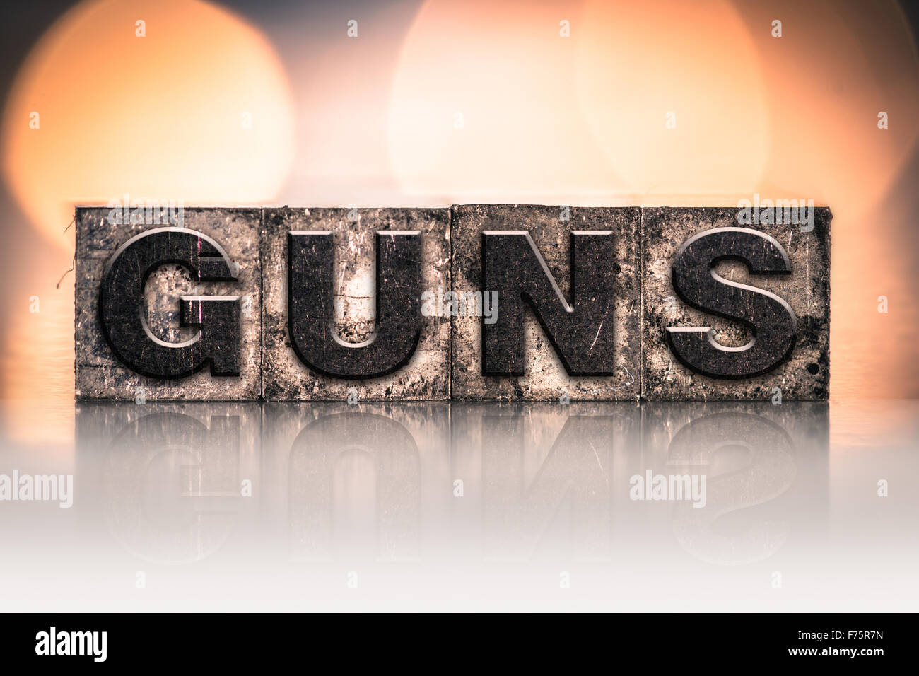 The word "GUNS" written in vintage ink stained letterpress type Stock ...