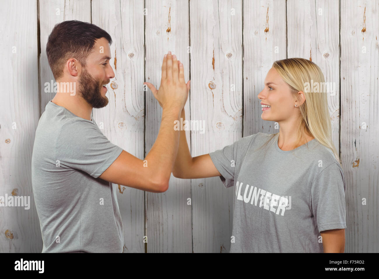Composite image of smiling volunteer doing high five in office Stock ...