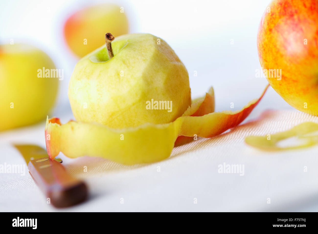 Yellow apple with peeled twisted skin Stock Photo - Alamy