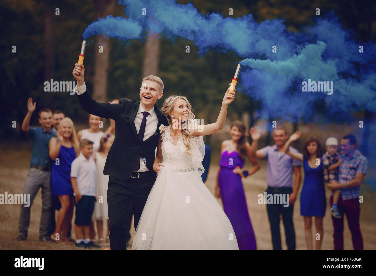 Wedding couple runs blue smoke Stock Photo - Alamy