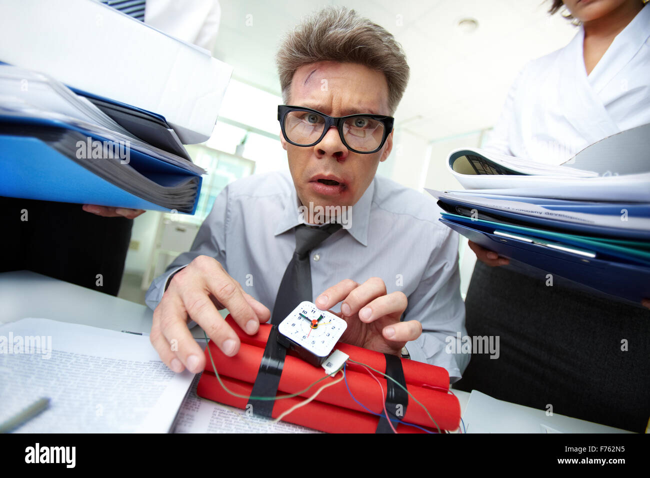 Annoyed businessman preparing dynamite while his colleagues giving him ...