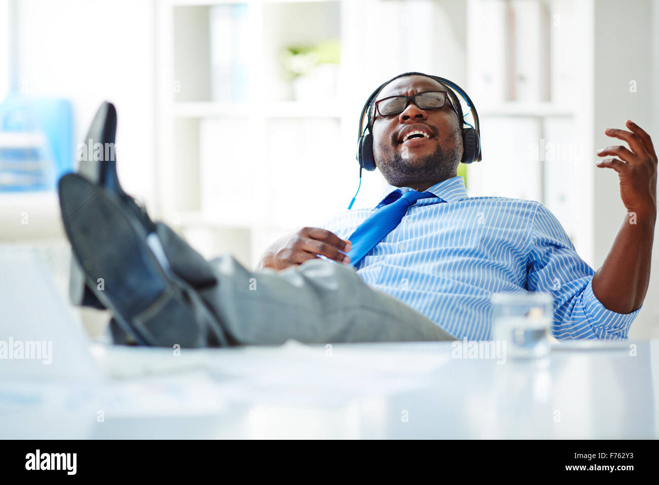 Businessman listening to music in headphones at office Stock Photo - Alamy