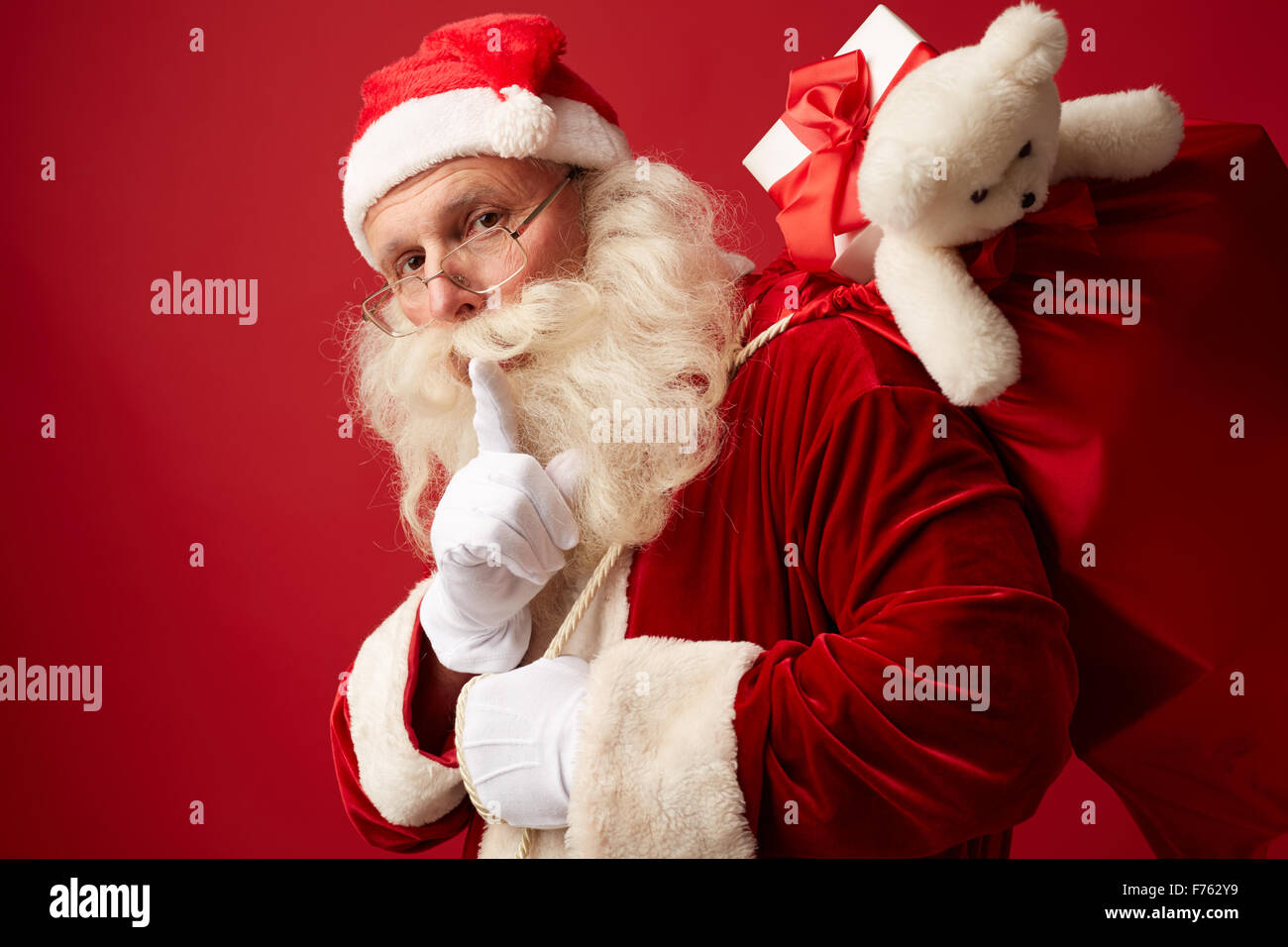 Santa Claus with big red sack keeping his forefinger by mouth Stock ...