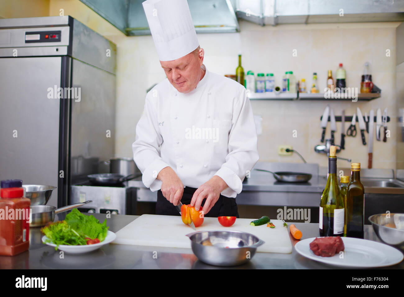 Cook cutting vegetables on cutting board Stock Photo - Alamy