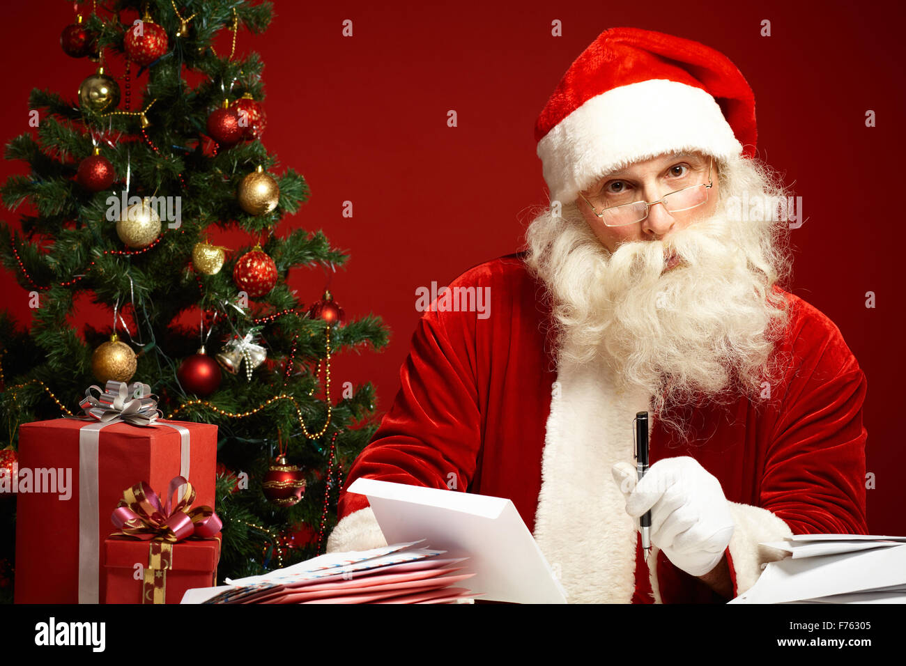 Santa answering Christmas letters by decorated fir-tree Stock Photo - Alamy