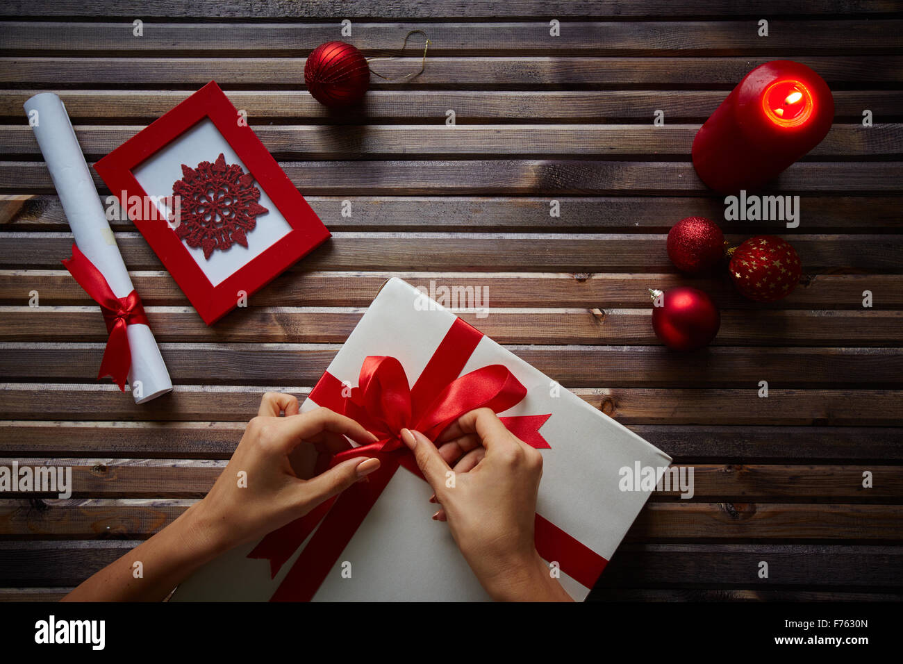 Female hands tying knot on giftbox with Christmas symbols near by Stock ...