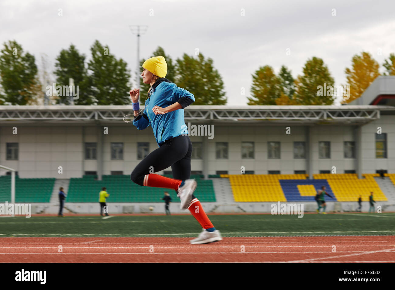 Side view of a fit young woman jogging at the stadium Stock Photo - Alamy